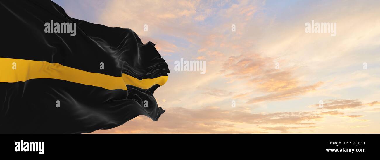 Thin Gold Line flag waving at cloudy sky background on sunset ...