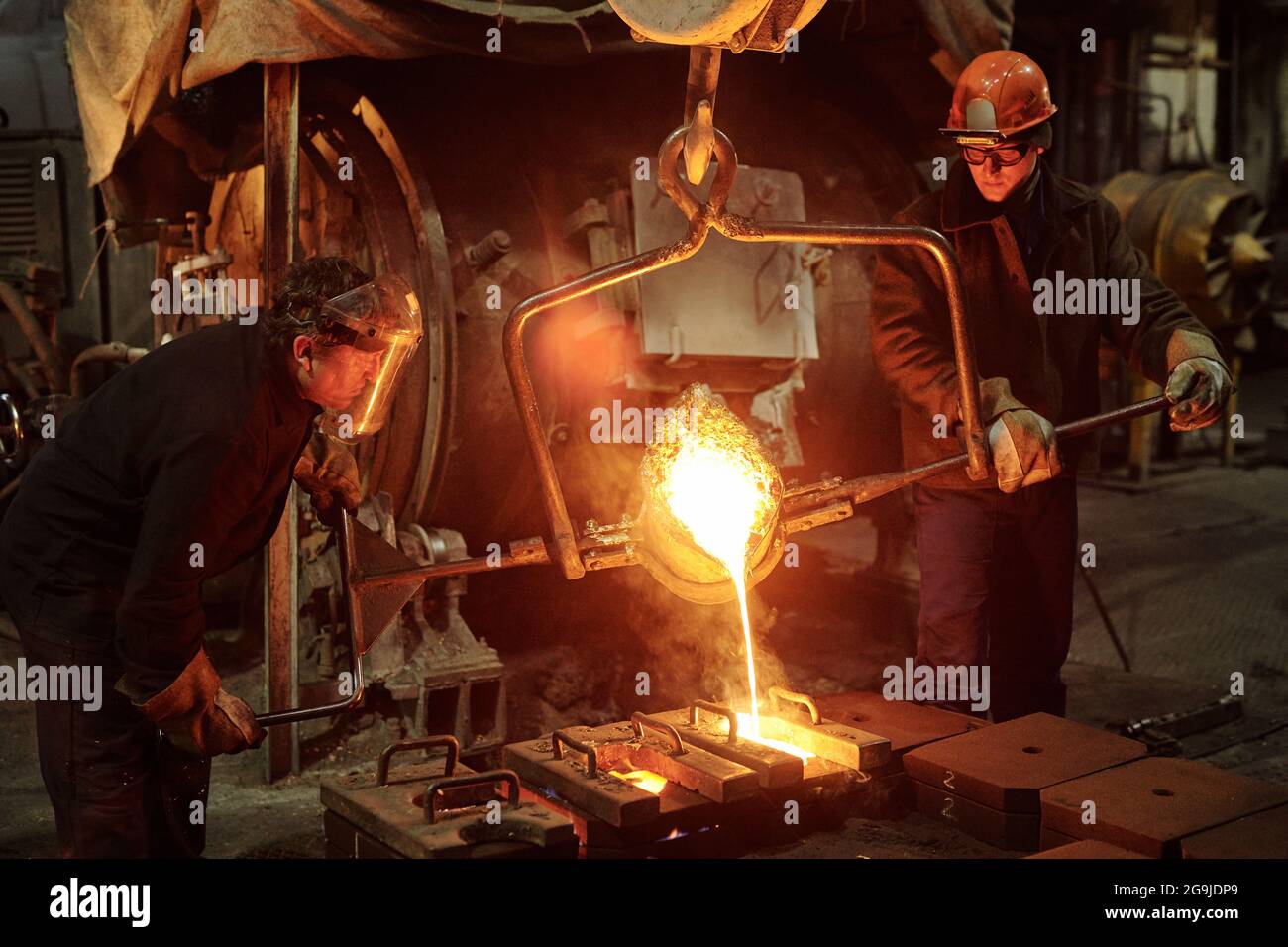 The welder works in the factory shop two steel workers melting metal ...