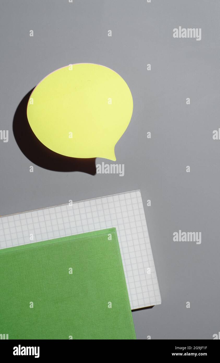 Green notepad, paper and yellow sticker on the blue background. Mock up ...