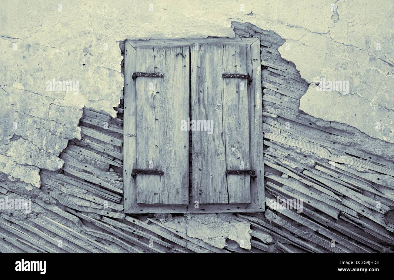 old wooden window on weathered wall that show structural timber-frame ...
