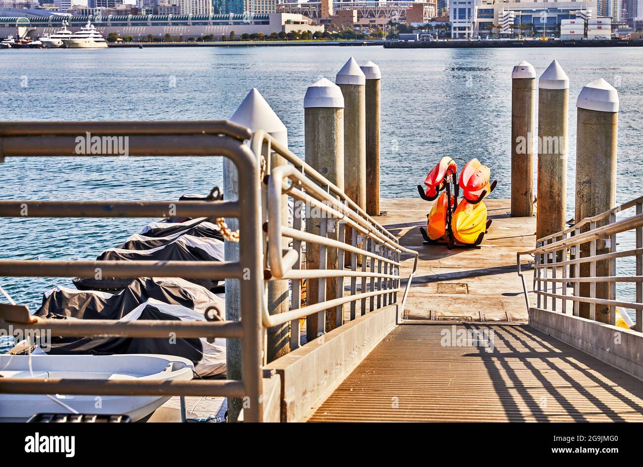 Kayaks sitting on a dock in a bay Stock Photo - Alamy