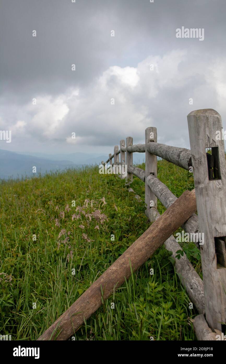 A rustic wooden fence in a meadow with the Blue Ridge Mountains in the ...