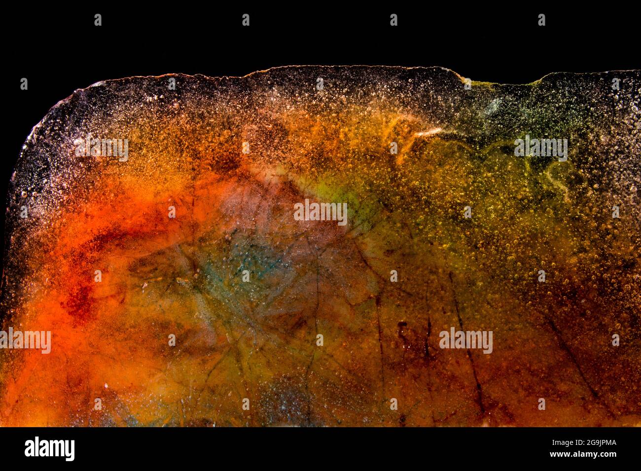 Ice plate melting. Multicolor. Colors trapped inside ice, flowing as ...