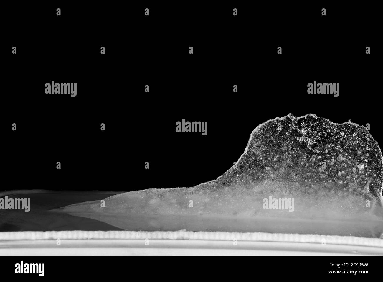 Ice plate melting, high contrast black background Stock Photo - Alamy
