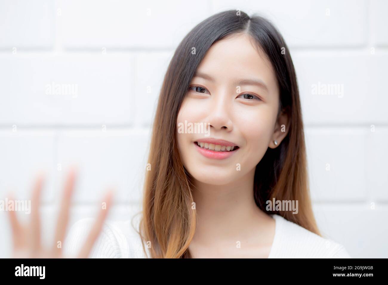 Beautiful young asian woman confident gesture say hello or greeting ...