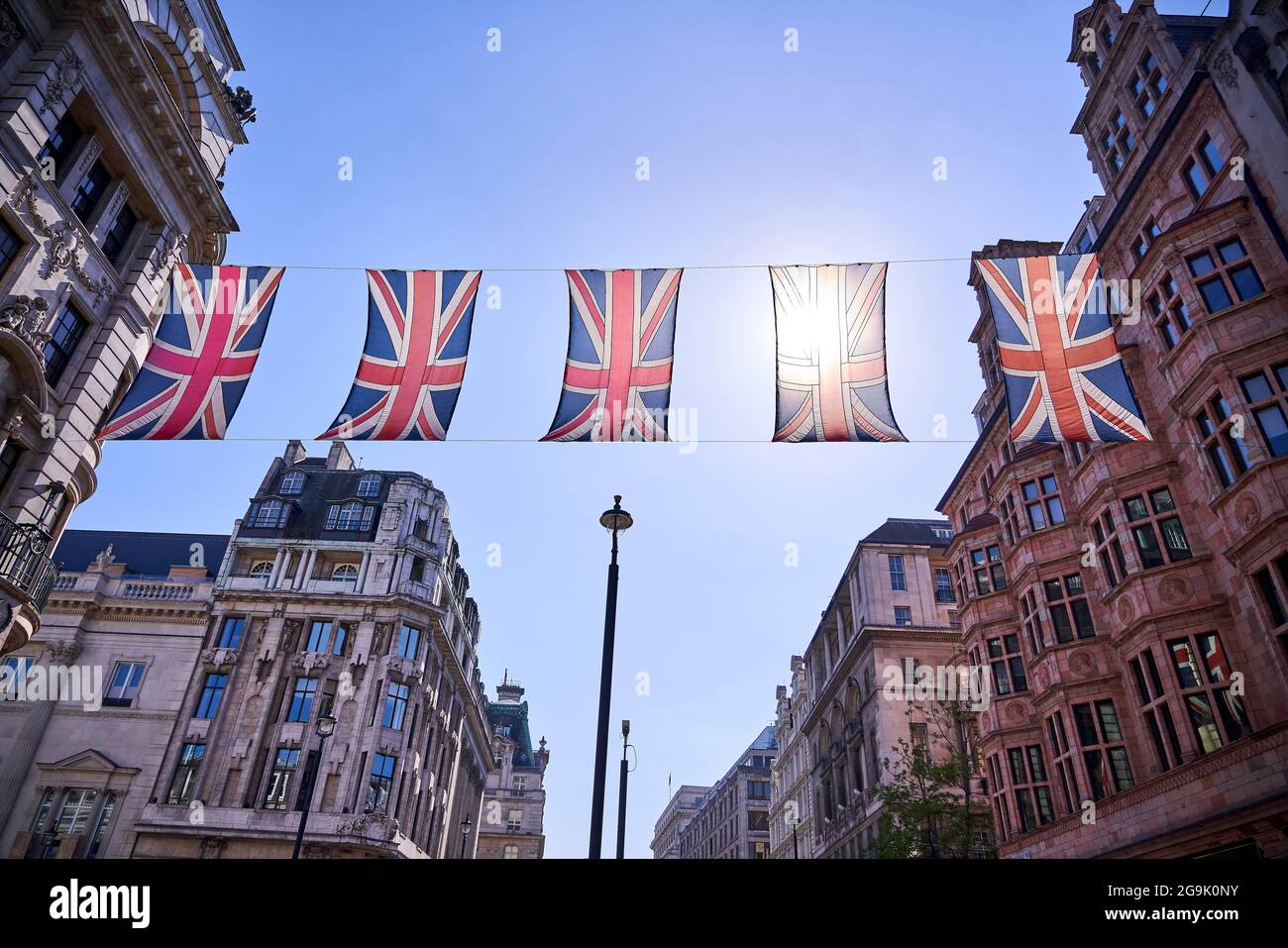 Union Jack flagging over street with old buildings, London, England ...