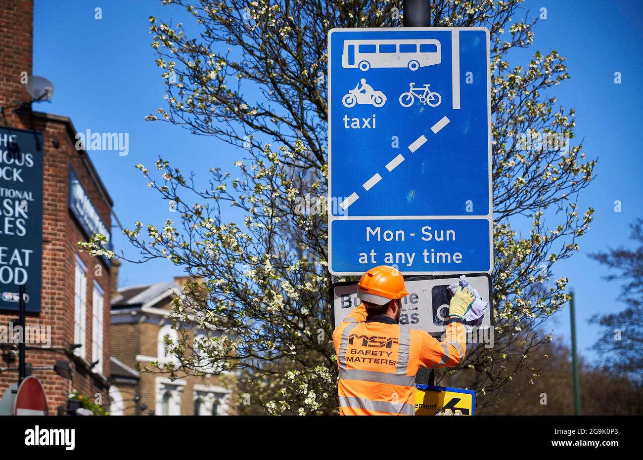 Construction worker cleaning traffic sign, London, England, United ...
