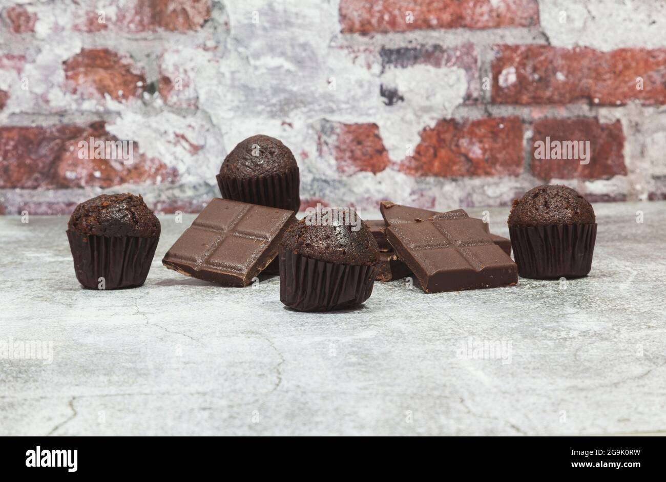 On a gray surface in front of a brick wall are several pieces of a dark ...