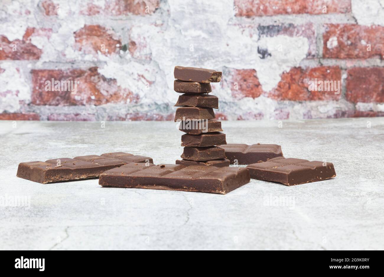 On a gray surface in front of a brick wall is a tower made of ounces of ...