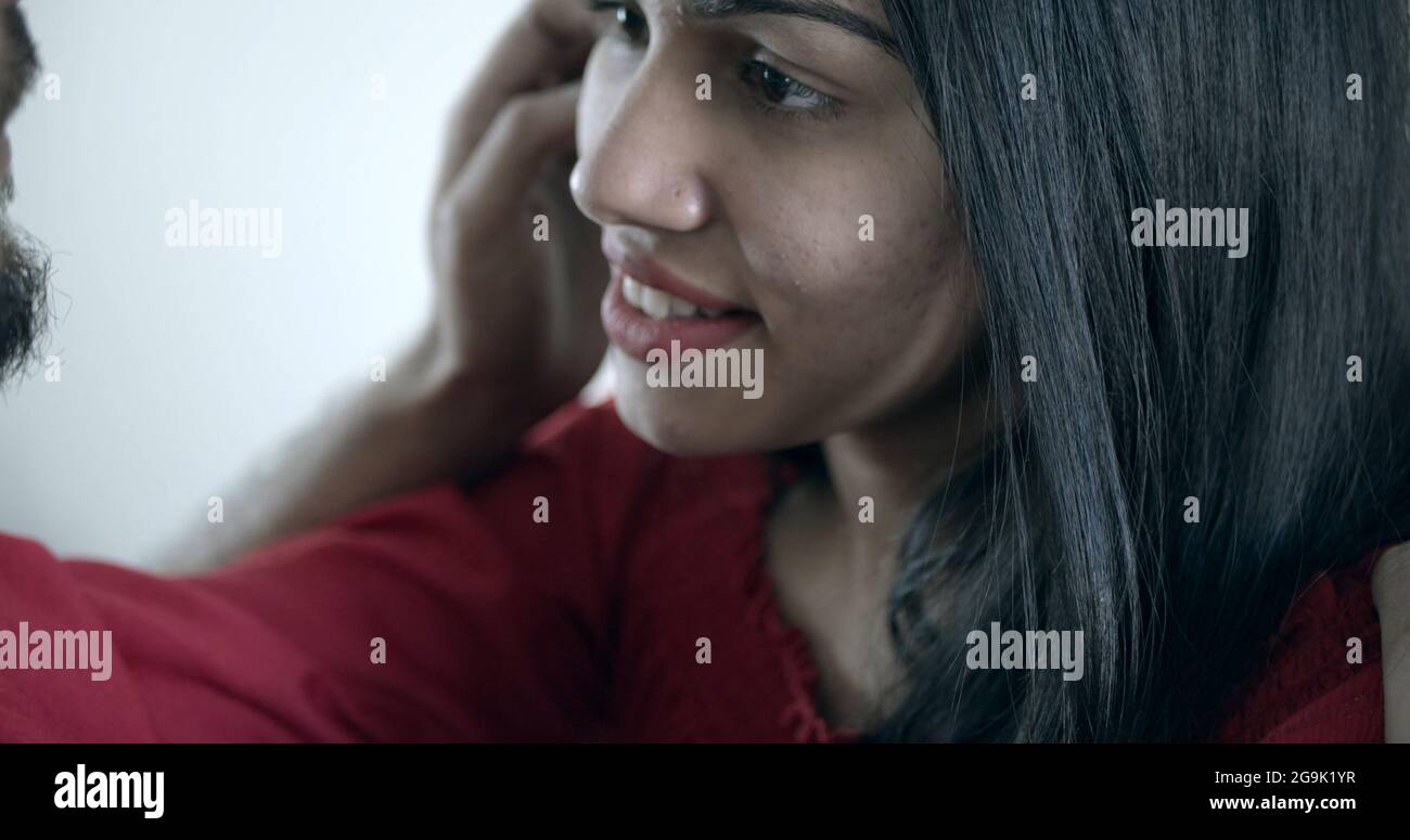 South Asian female happily looking at her lover who caresses her hair ...