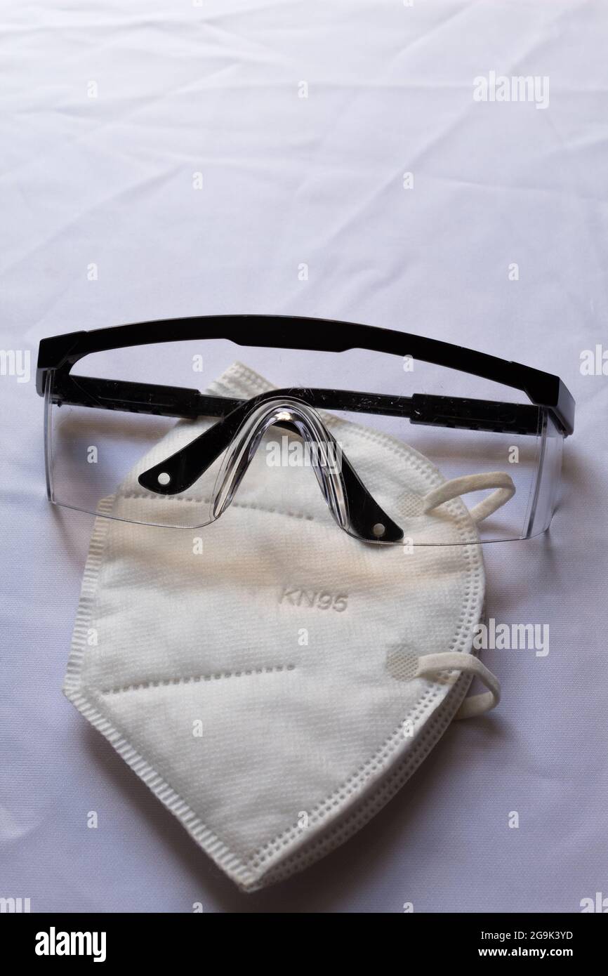 kn95 face mask and protective glasses on a wrinkled white background ...
