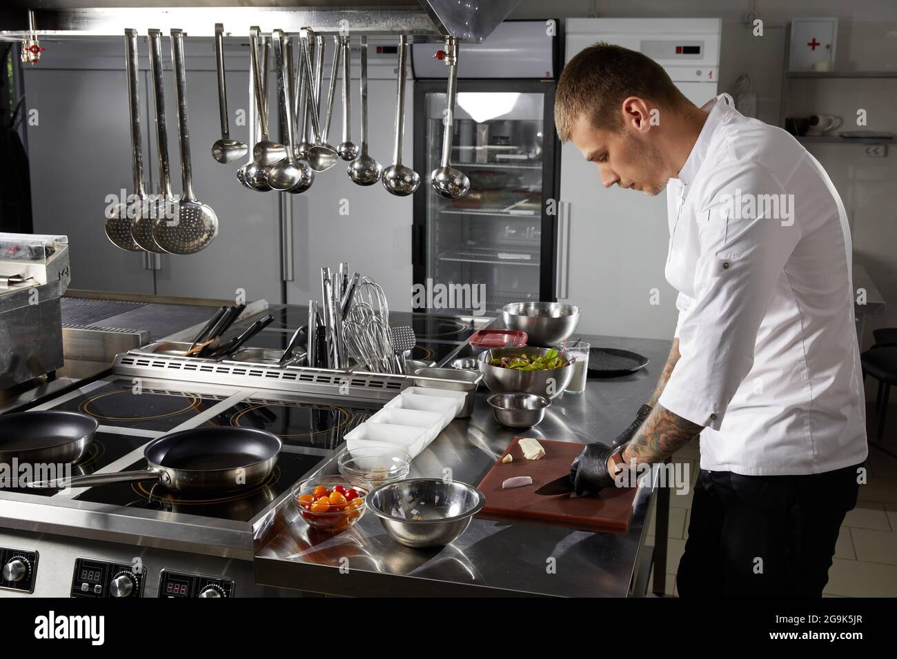 Professional chef cooking in the modern kitchen in hotel restaurant ...
