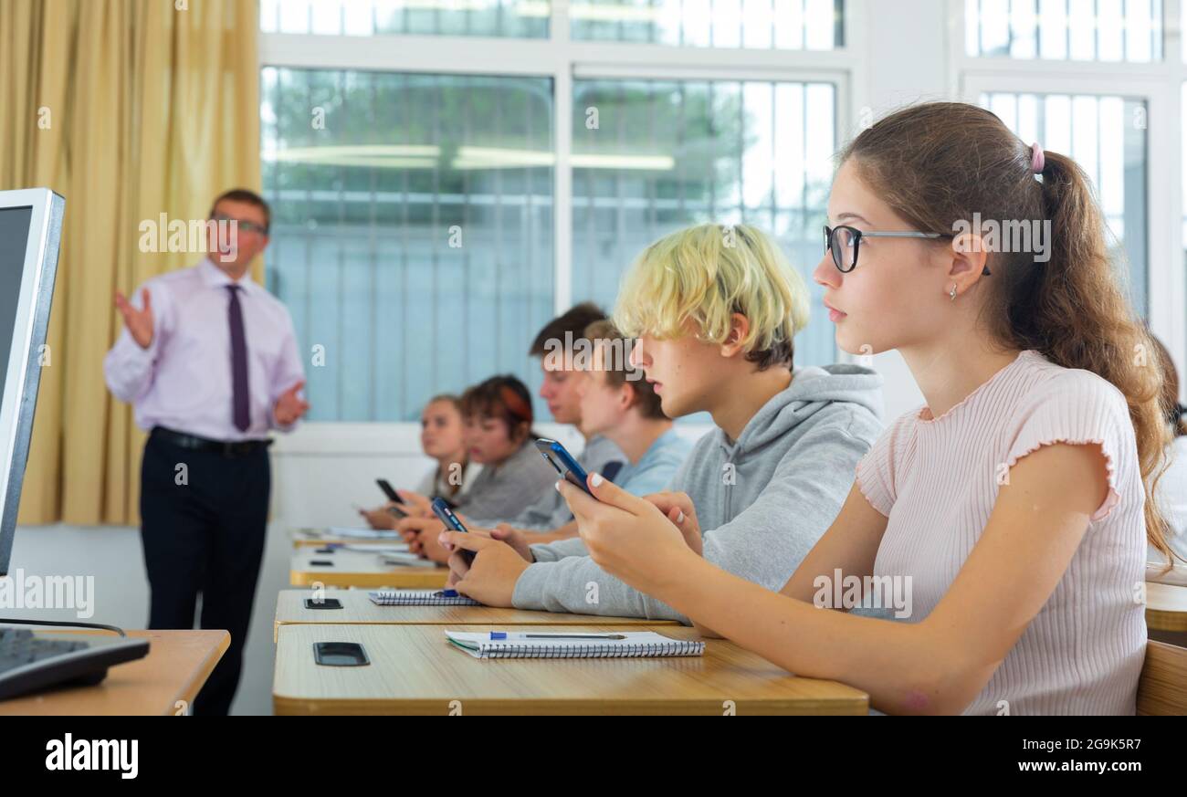 Side view of student group working with mobile phones in class Stock ...