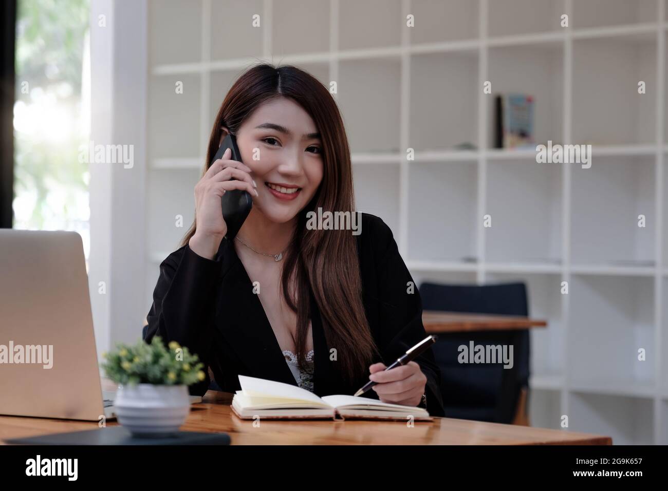 Asian business woman making a phone call and smiling look at camera ...