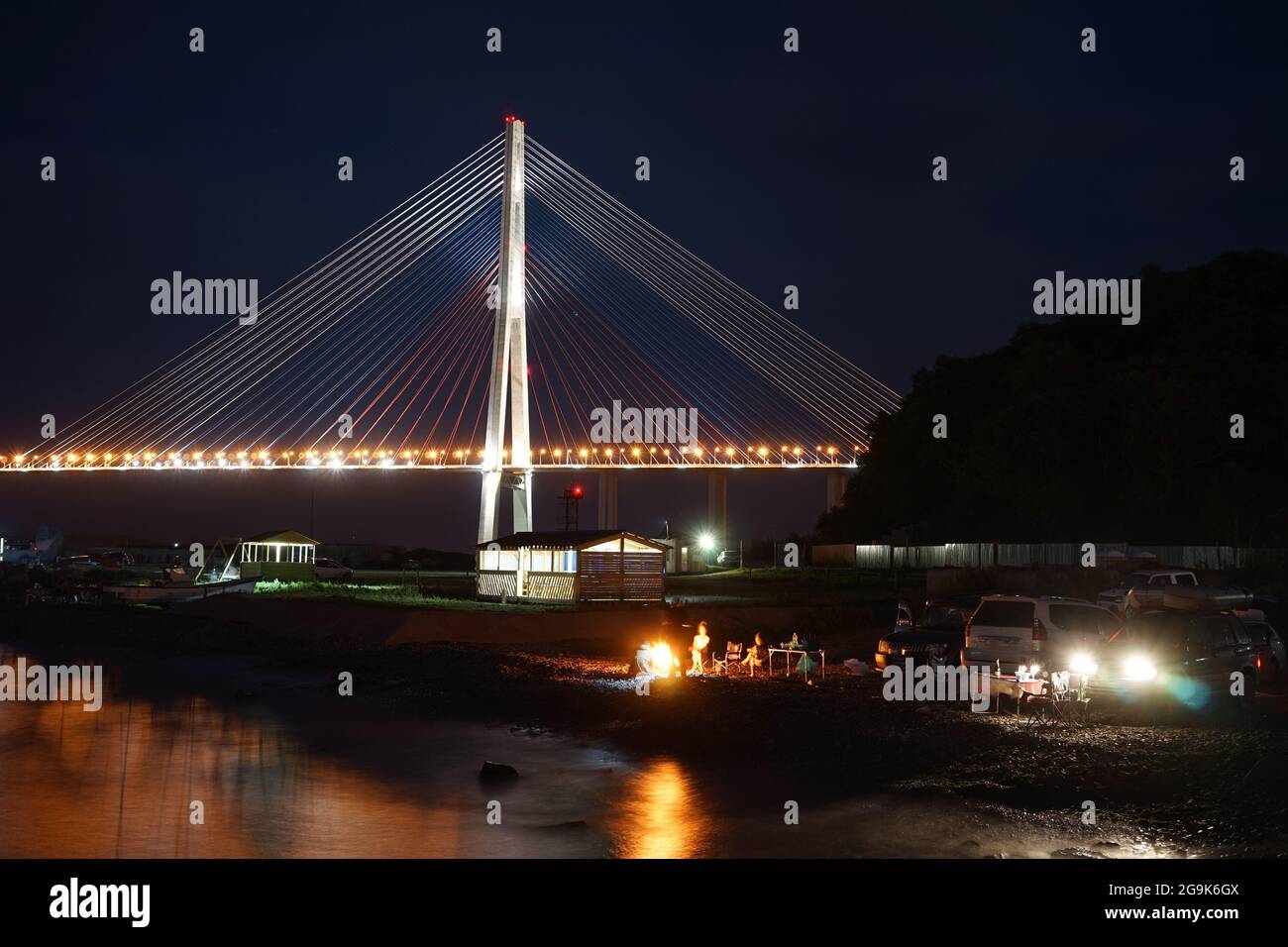 Night landscape with views of the Russian bridge. People relax on the ...
