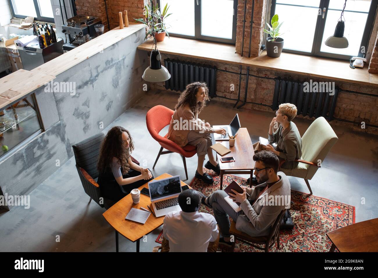 Group of intercultural co-workers discussing working points at meeting ...