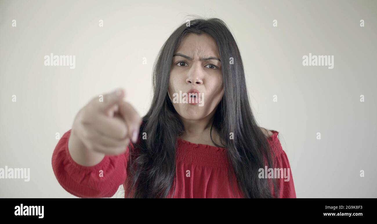 Angry South Asian female on a white wall background Stock Photo - Alamy