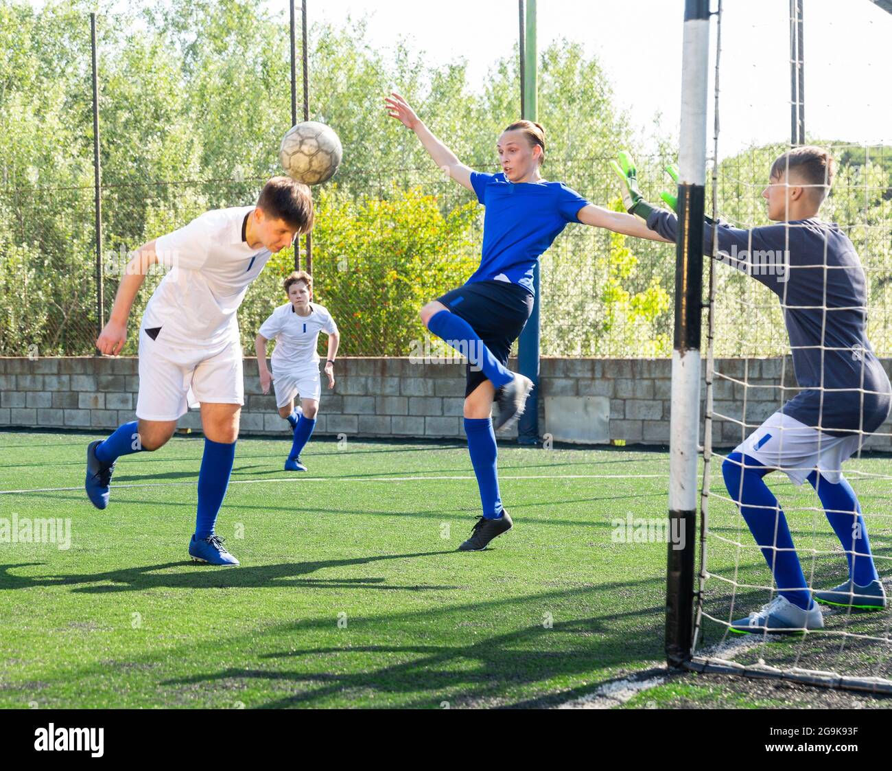 Heading ball towards the goal. Football match between two youth teams ...