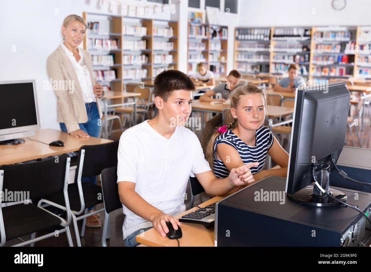 Schoolchildren using computers in classroom Stock Photo - Alamy