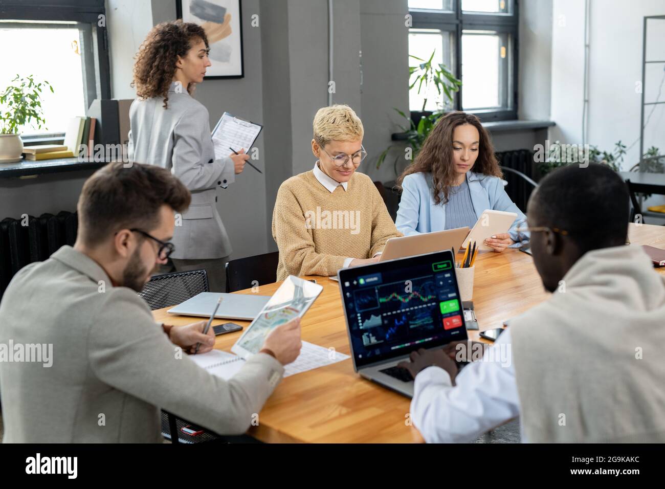 Group of co-workers using mobile gadgets during individual work by ...