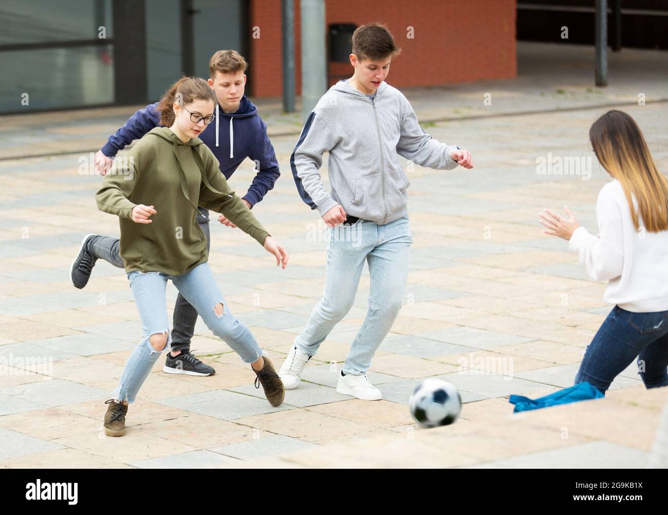 Teenagers playing soccer with ball outside Stock Photo - Alamy