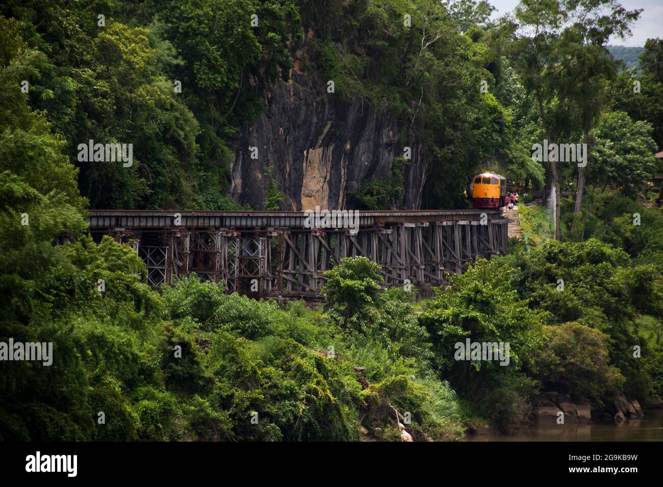 Train running on track between hellfire pass mountain and riverside Sai ...