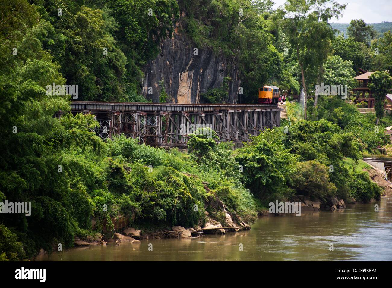 Train running on track between hellfire pass mountain and riverside Sai ...