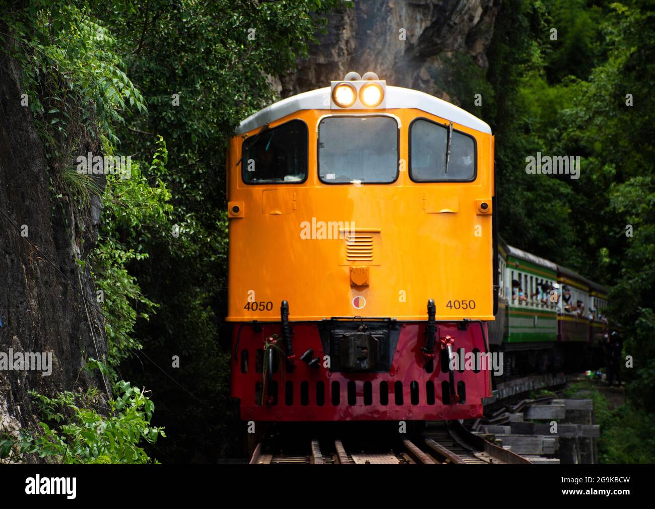 Train running on track between hellfire pass mountain and riverside Sai ...