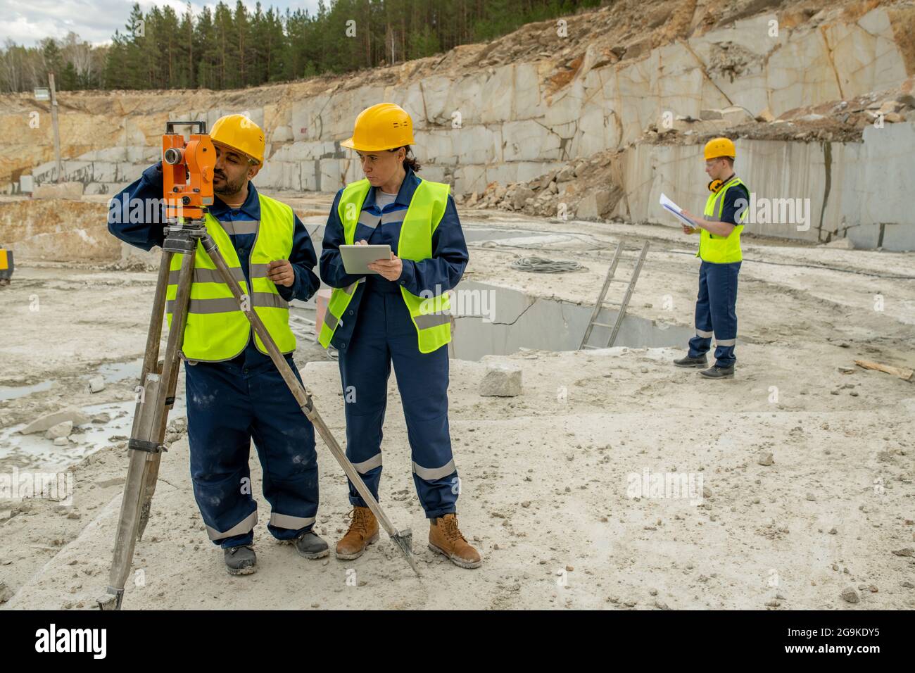 Two professional surveyors working by total station at construction ...