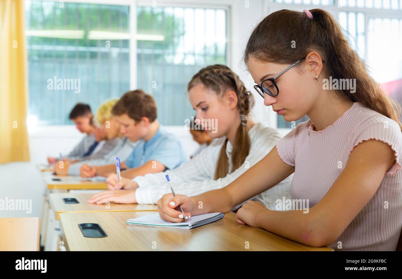 Students listening task for exam in classroom Stock Photo - Alamy