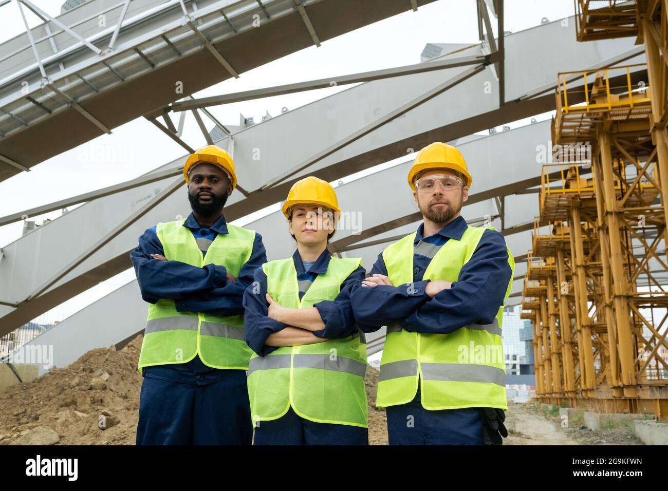 Portrait of group of engineers in reflective clothing and work helmets ...