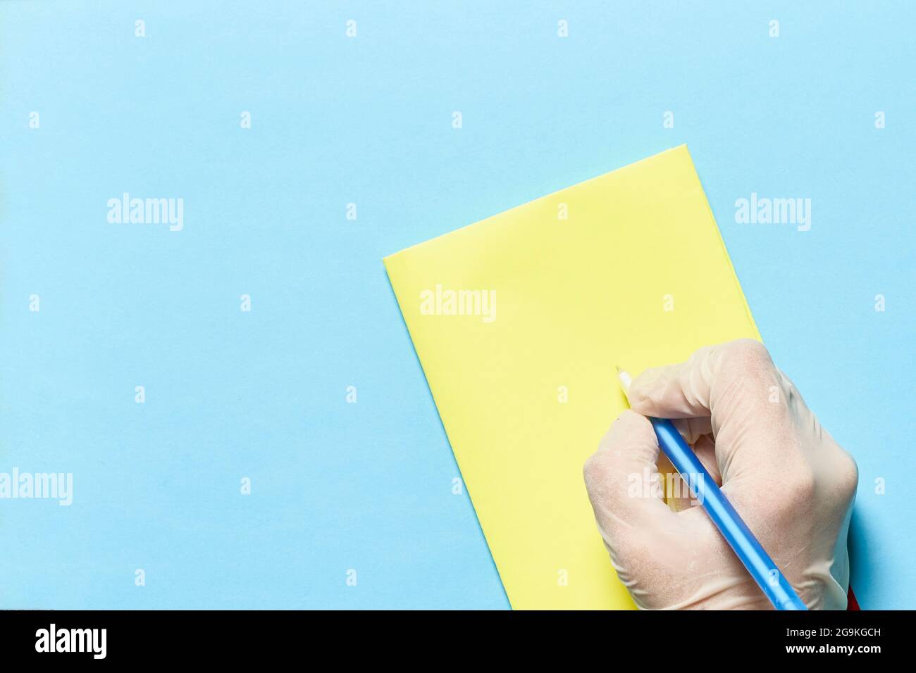 Hand in medical gloves writing on yellow paper with copy space Stock ...