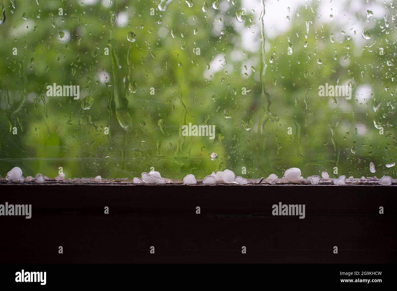 Hail over wooden window frame. Selective focus over green background ...