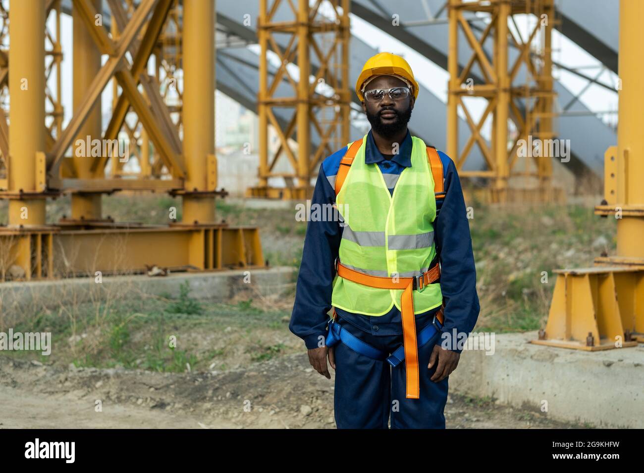 Portrait of African construction worker in equipment looking at camera ...