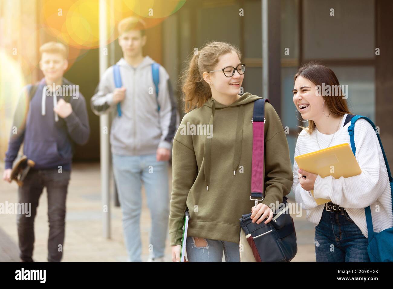 Two cheerful carefree female students walking down street Stock Photo ...