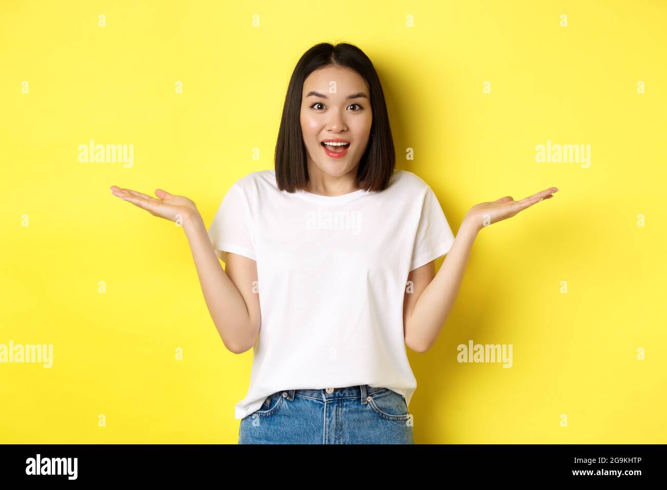 Beauty and fashion concept. Surprised asian girl spread hands sideways ...