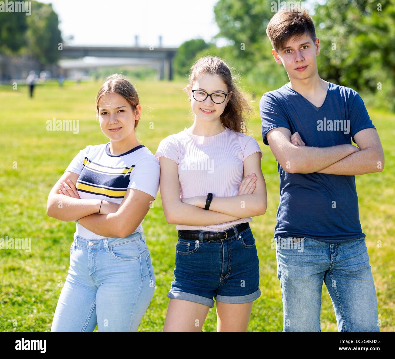 Three happy confident teenagers in summer city park Stock Photo - Alamy