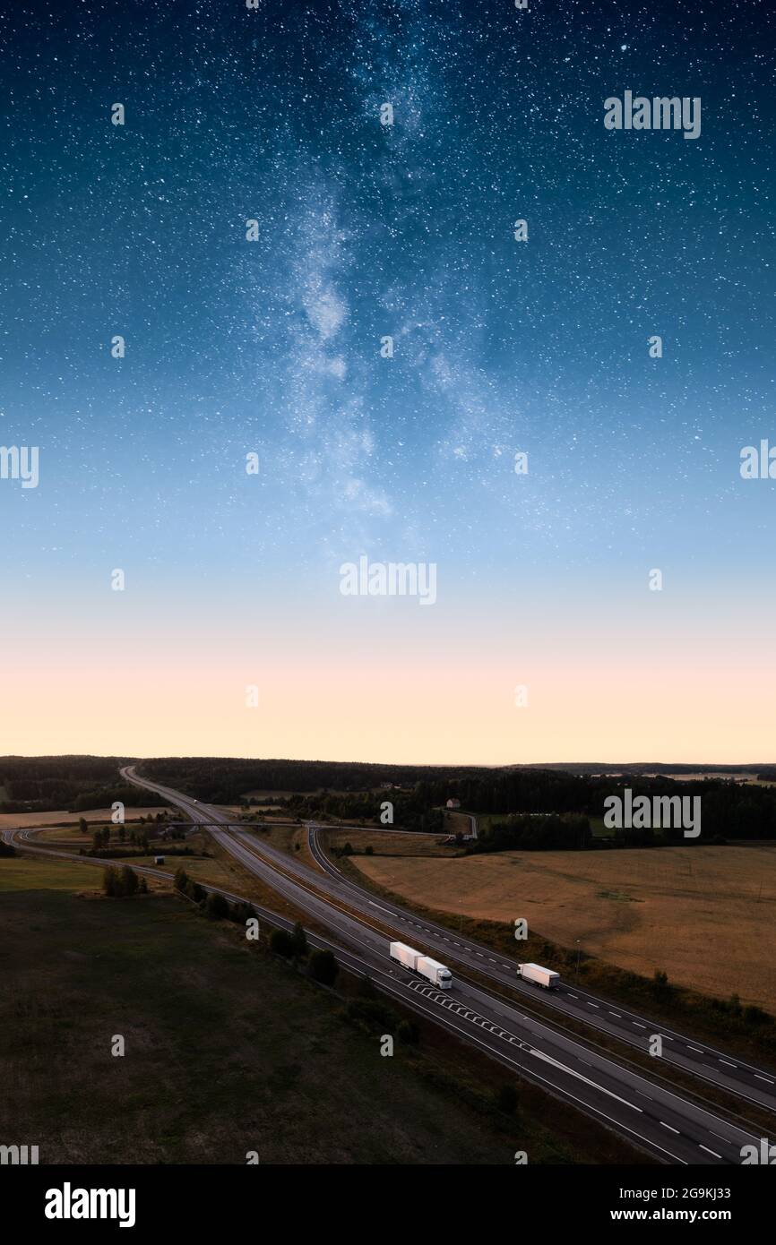 Truck on a highway with an epic milky way and stars sky above ...