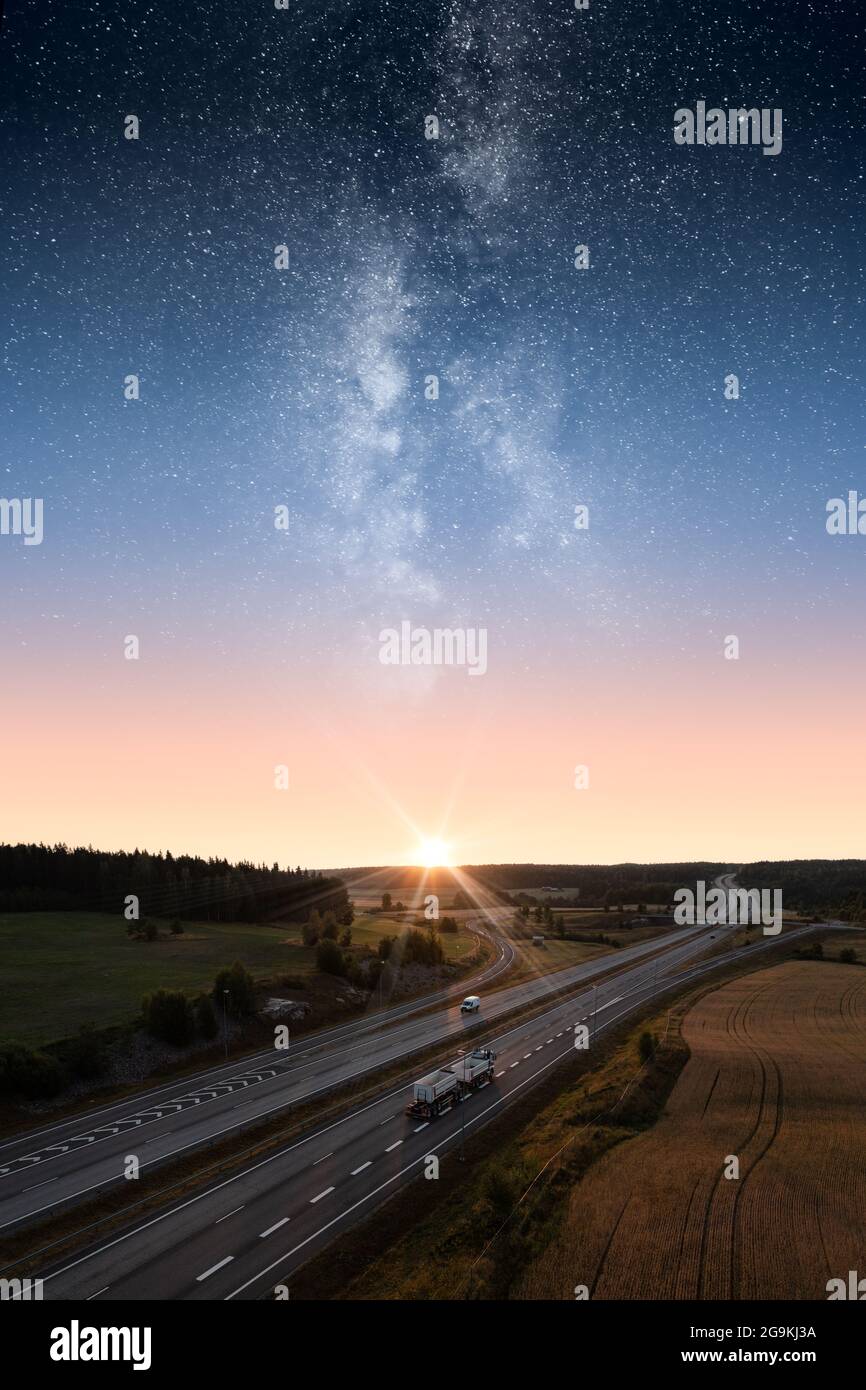 Vehicles on a freeway under an epic star sky and milky way. Freight ...