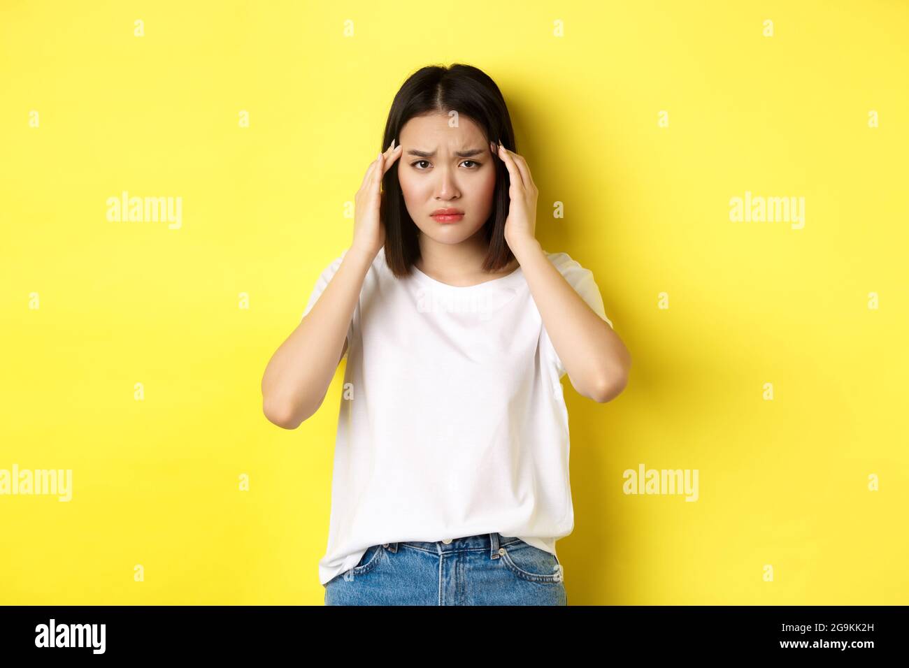 Sad asian girl touching head and frowning, feeling sick, having ...