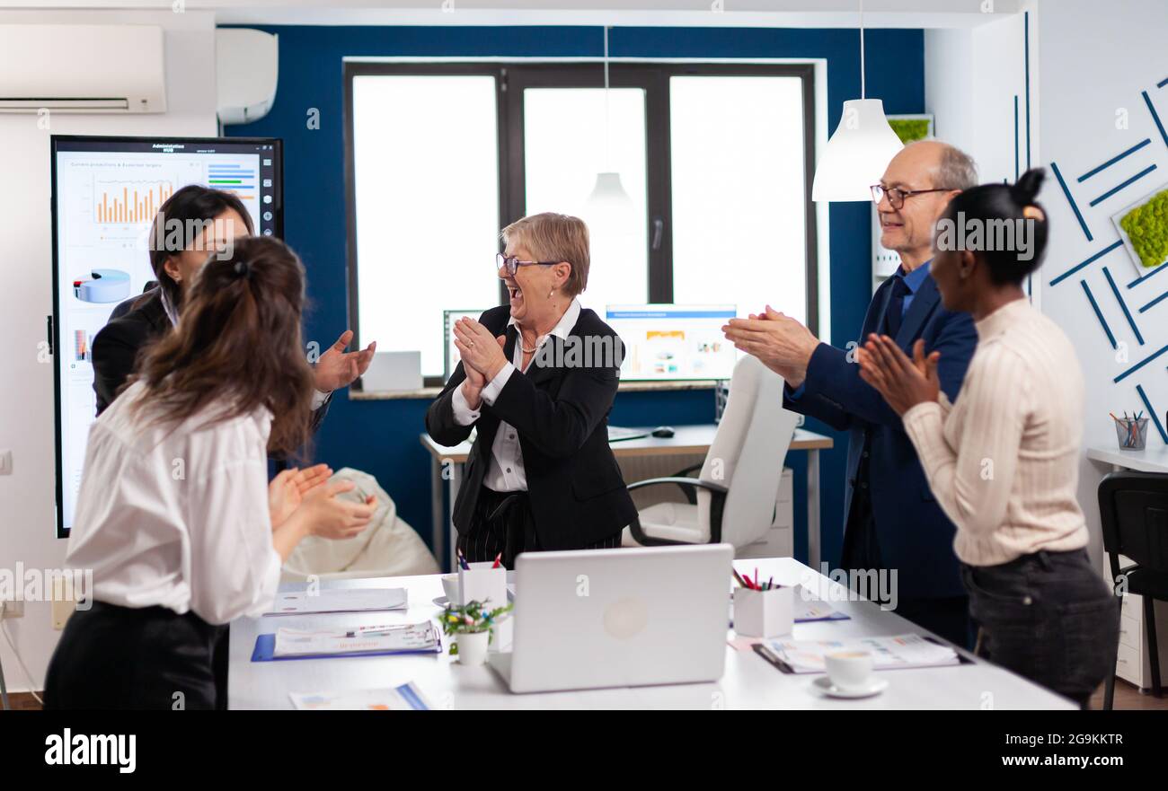 Happy excited diverse team of financial team in conference room after ...