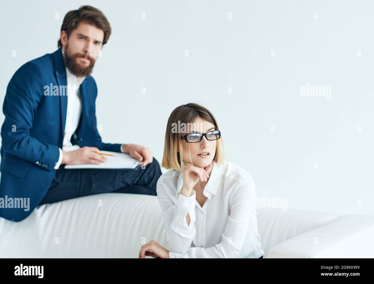 man and woman sitting on the couch communication work professionals ...