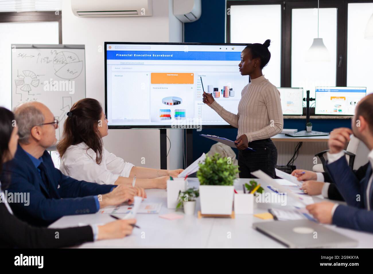 African leader briefing business organization pointing at graph ...