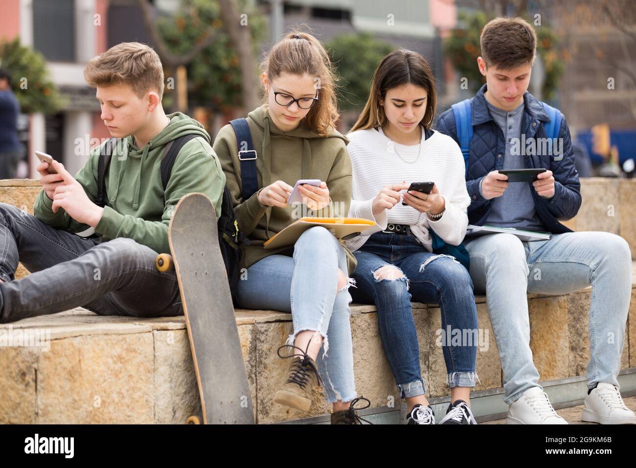 Group of teens using smartphones outdoors Stock Photo - Alamy