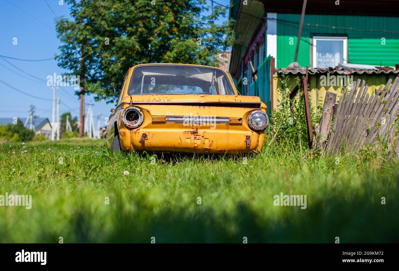Old yellow wrecked car in vintage style. Abandoned rusty yellow car ...