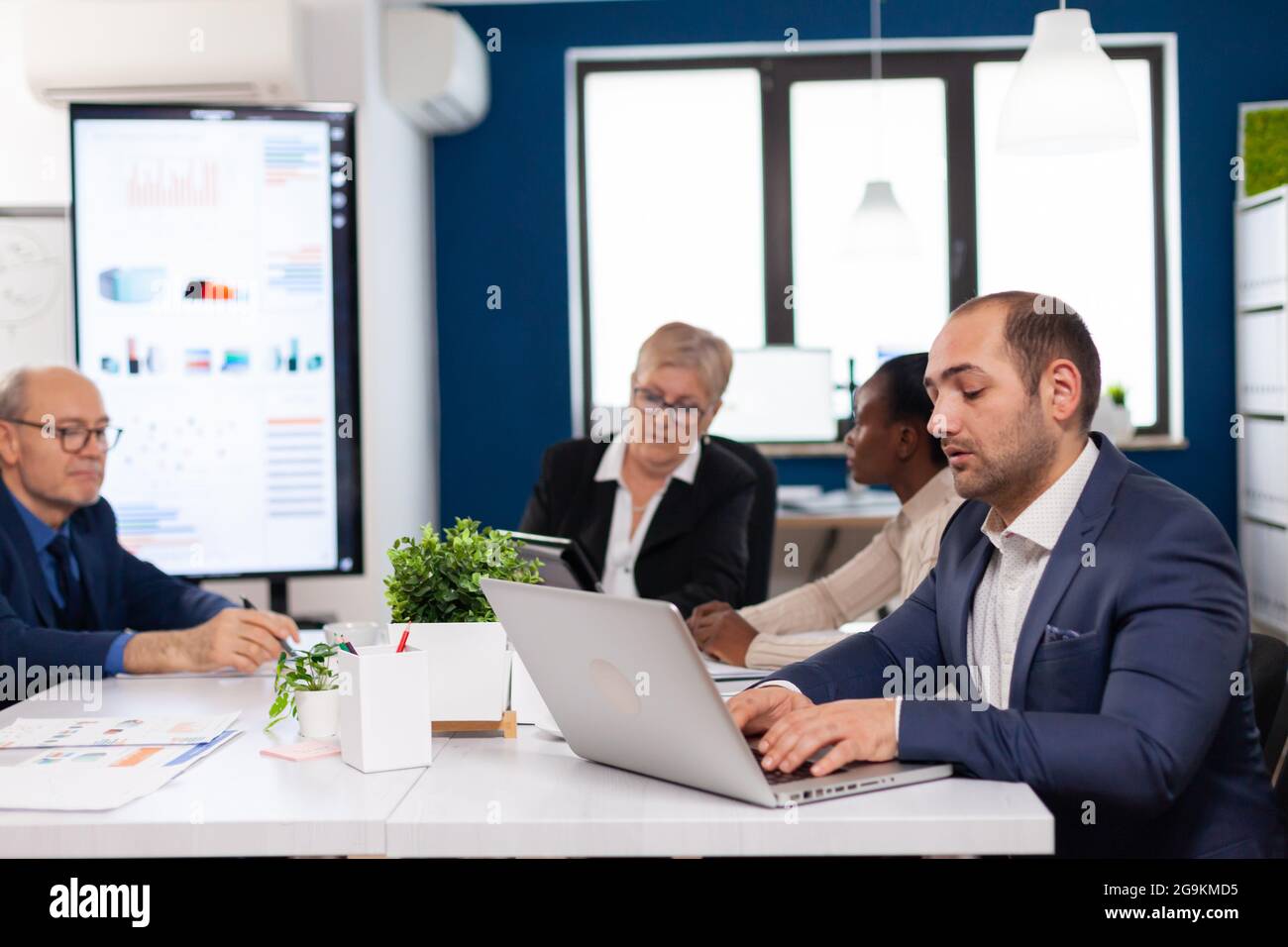 Busy business man using laptop typing sitting at conference table in ...
