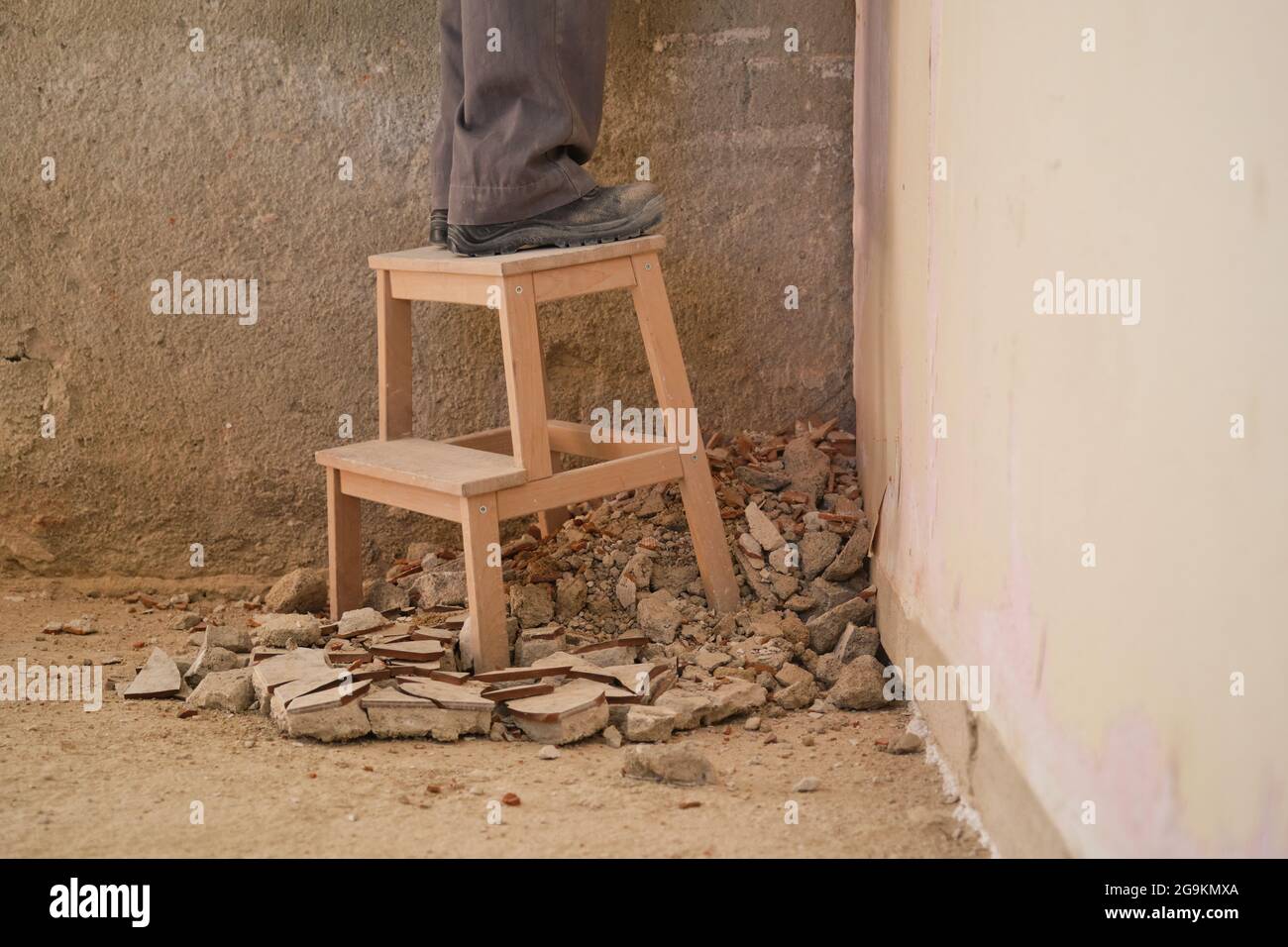 Close up of a young caucasian construction worker legs on a small wood ...