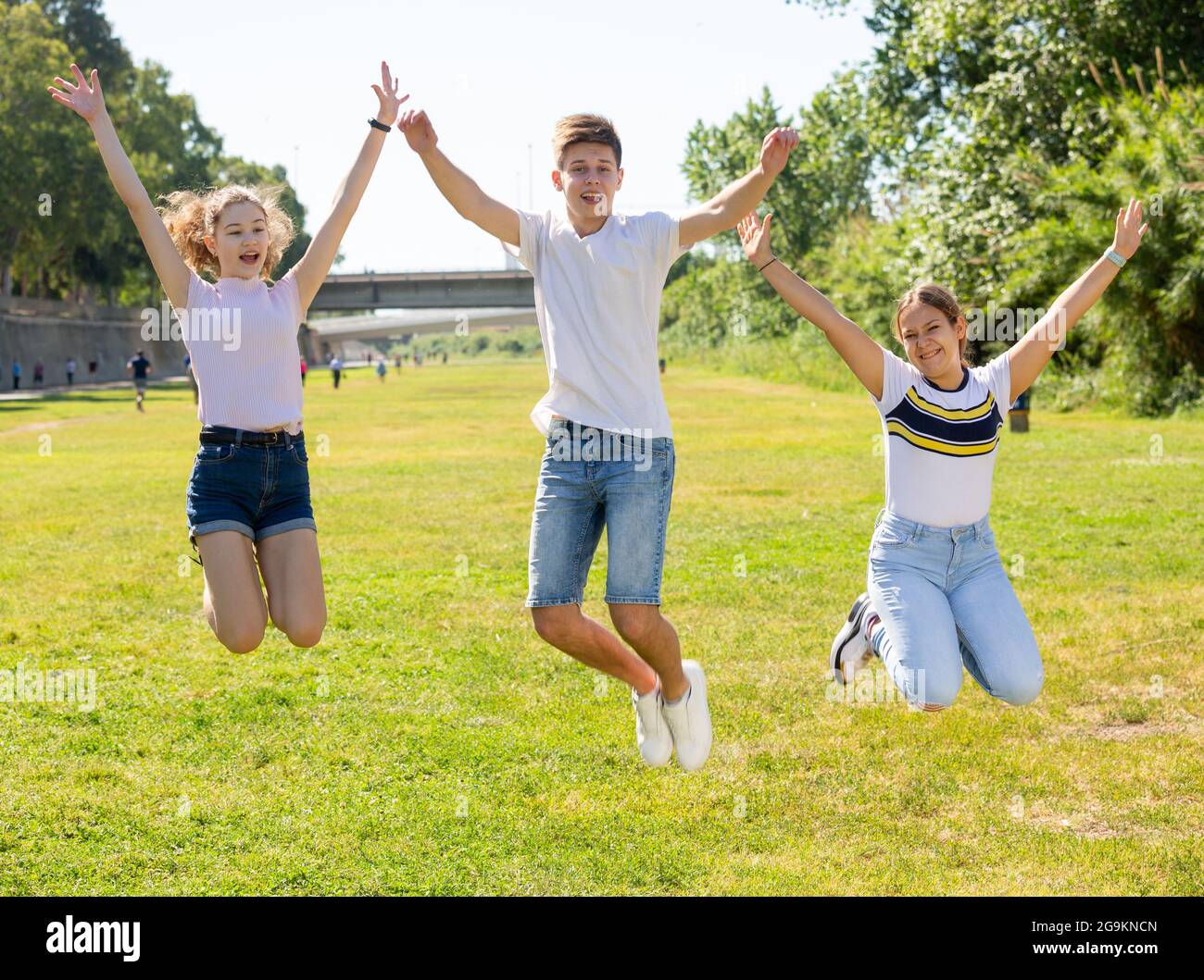 Happy teenagers jumping on the green lawn Stock Photo - Alamy