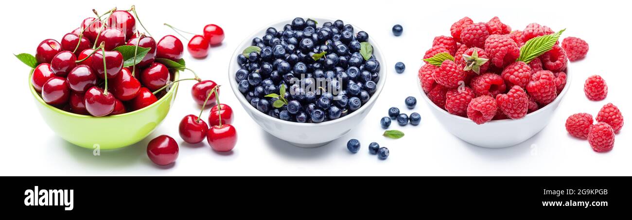 Three plates with blueberries, cherries and raspberries isolated on a ...