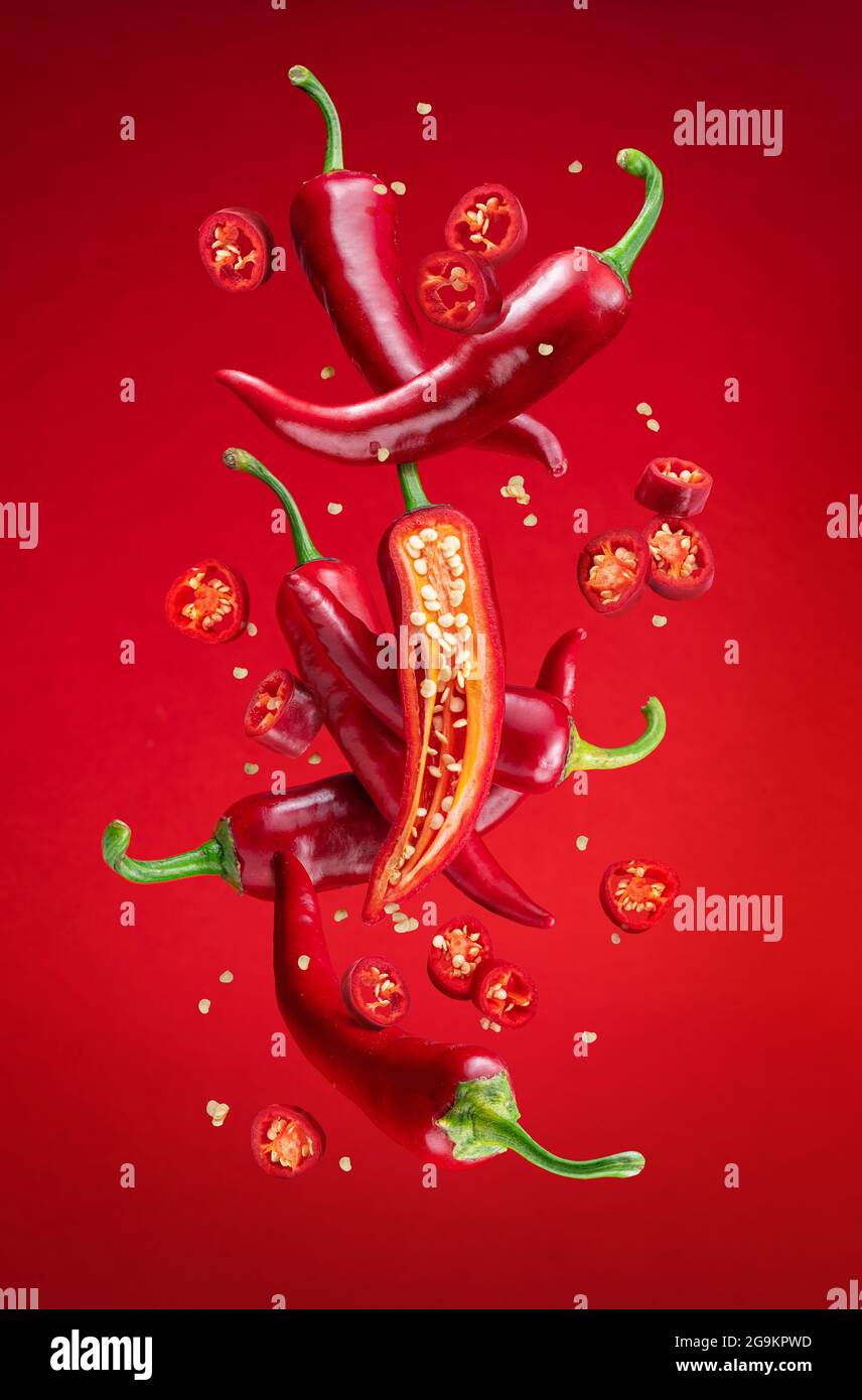 Fresh red chilli peppers and cross sections of chilli pepper with seeds ...